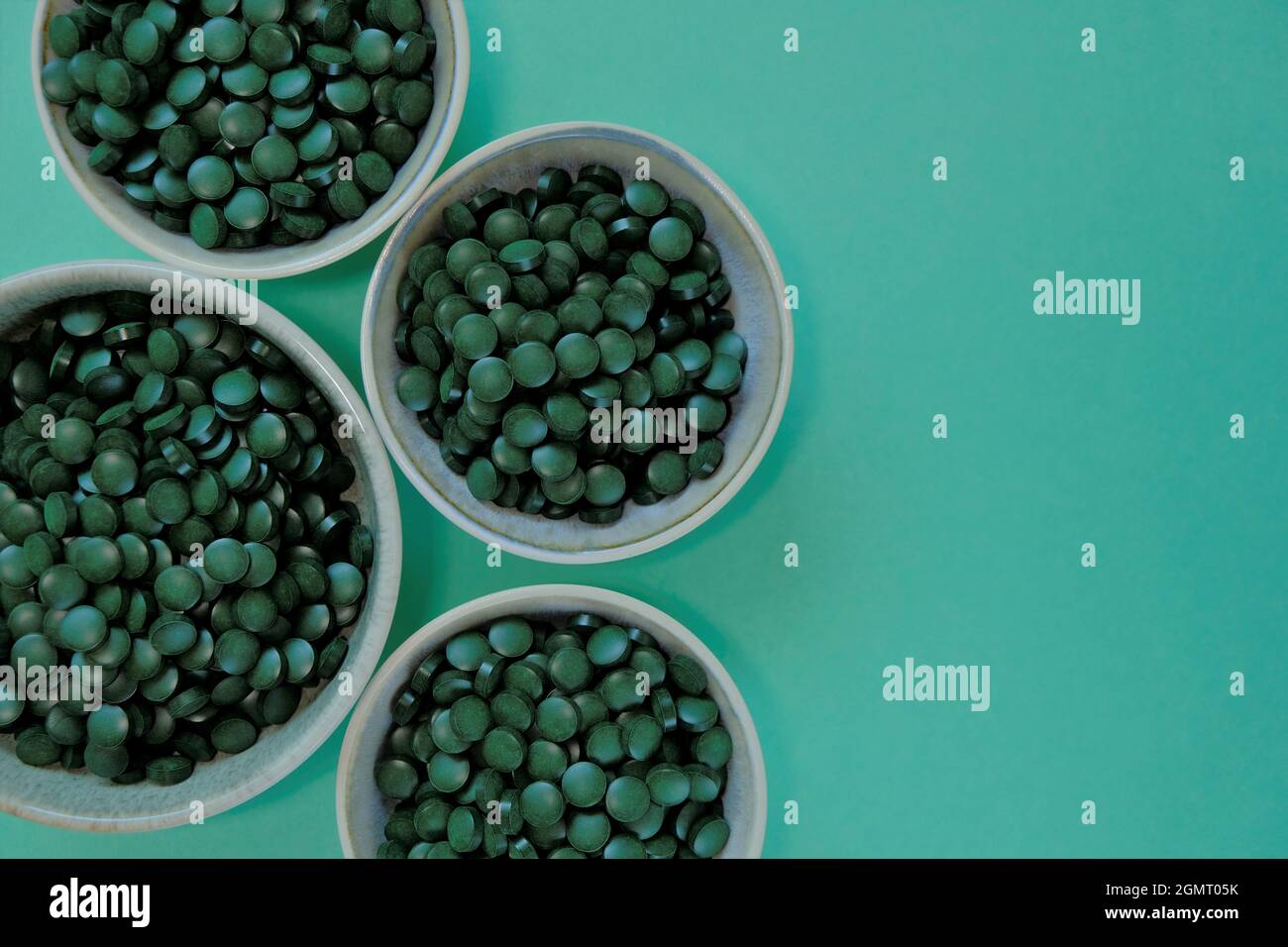 Spirulina algae tablets. Spirulina pills in cups . Vegetarian omega ...