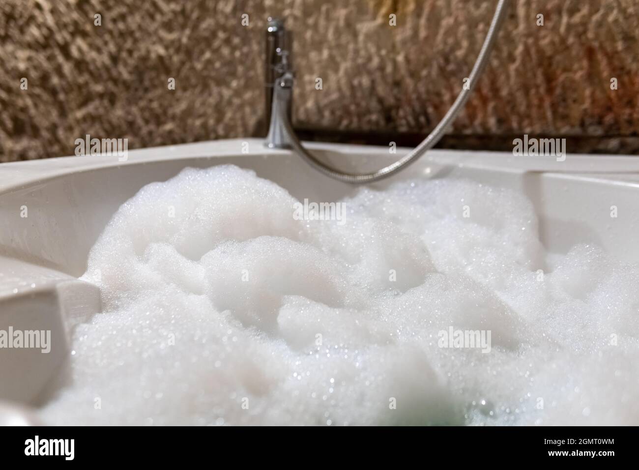 Jacuzzi, a foamy water, natural stone walls and a vintage bathroom ...