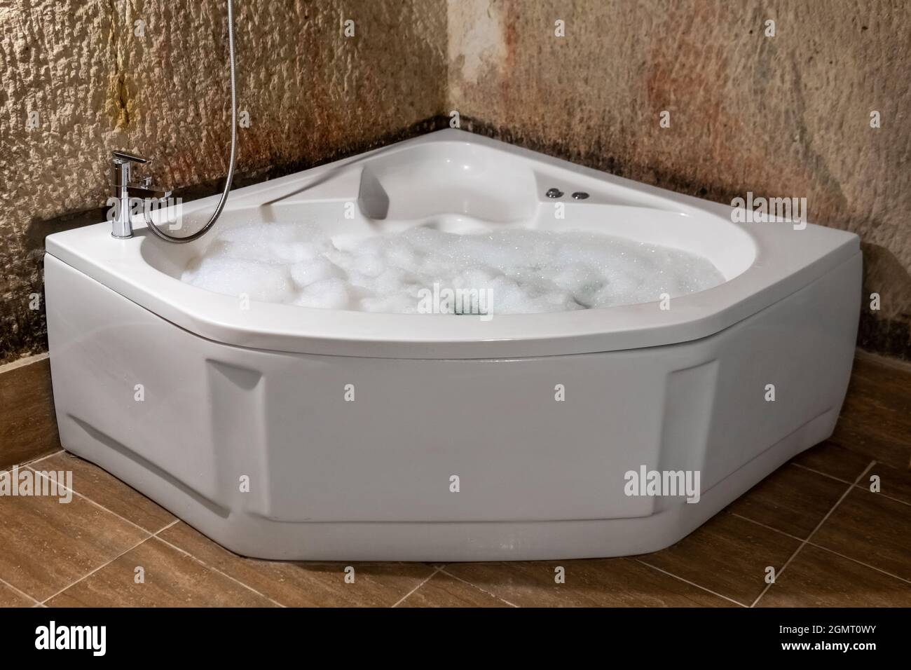 Jacuzzi, a foamy water, natural stone walls and a vintage bathroom ...