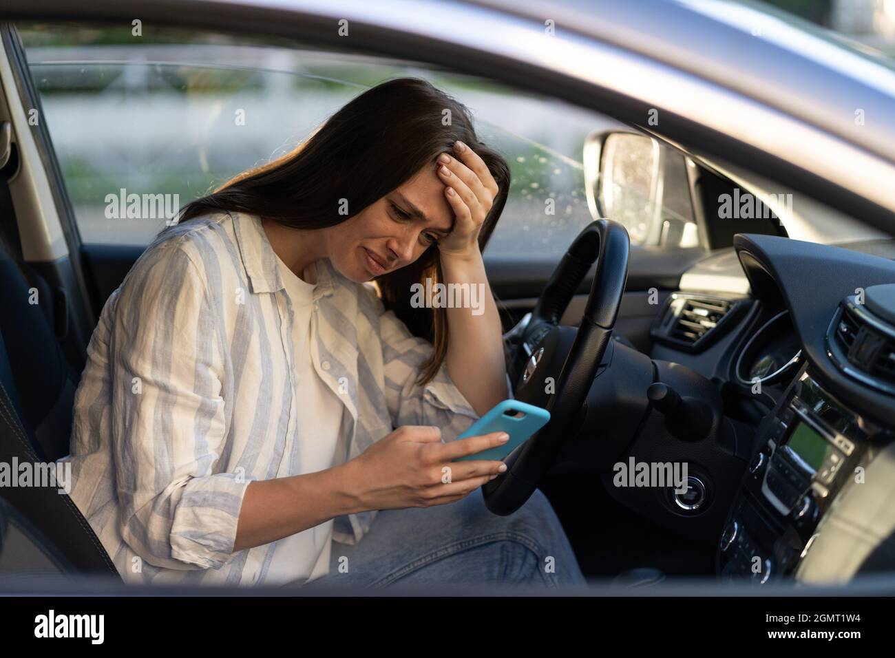 Unhappy girl cry reading sms message in smartphone driving car. Upset ...