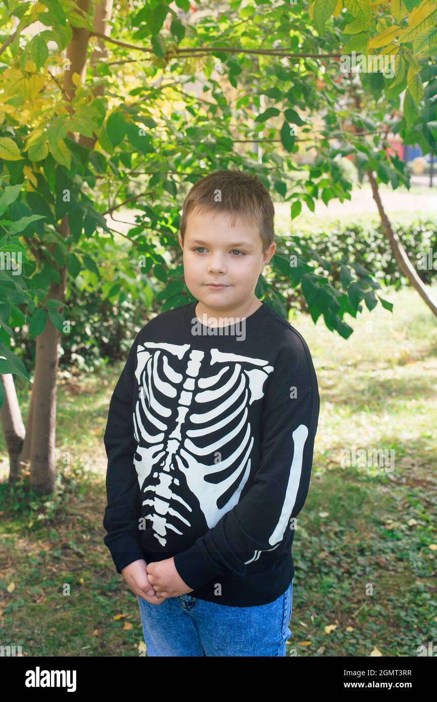 Little boy in a skeleton costume is ready to celebrate Halloween. Boy ...