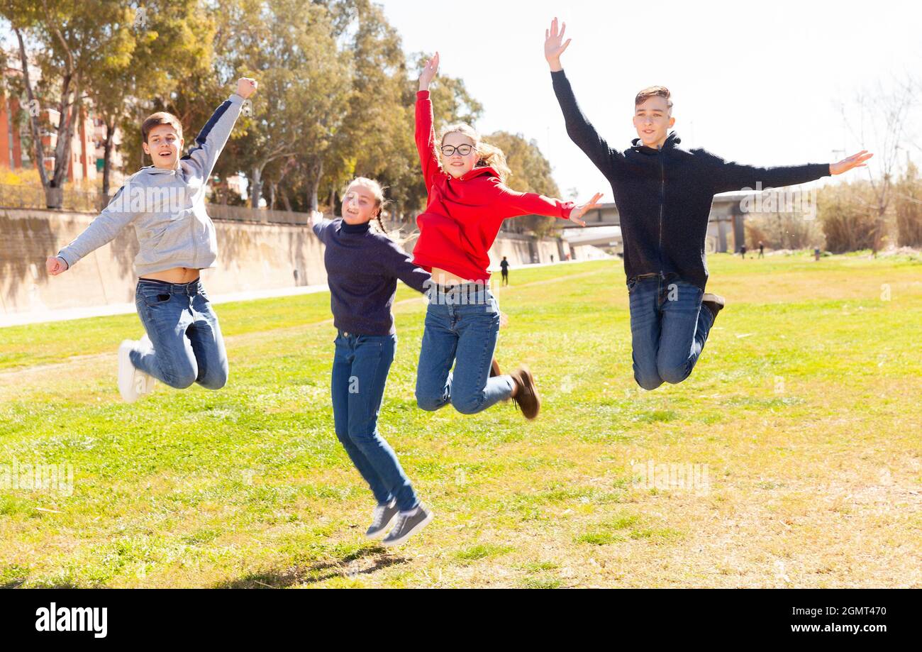 Teenagers jumping on green lawn Stock Photo - Alamy