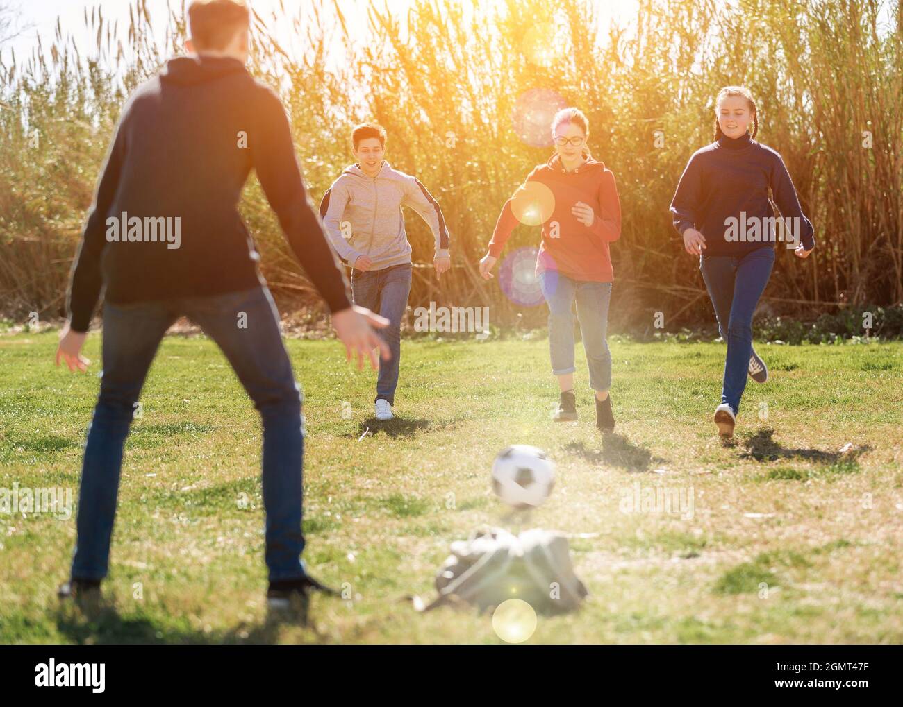 Teenagers playing football outdoors Stock Photo - Alamy