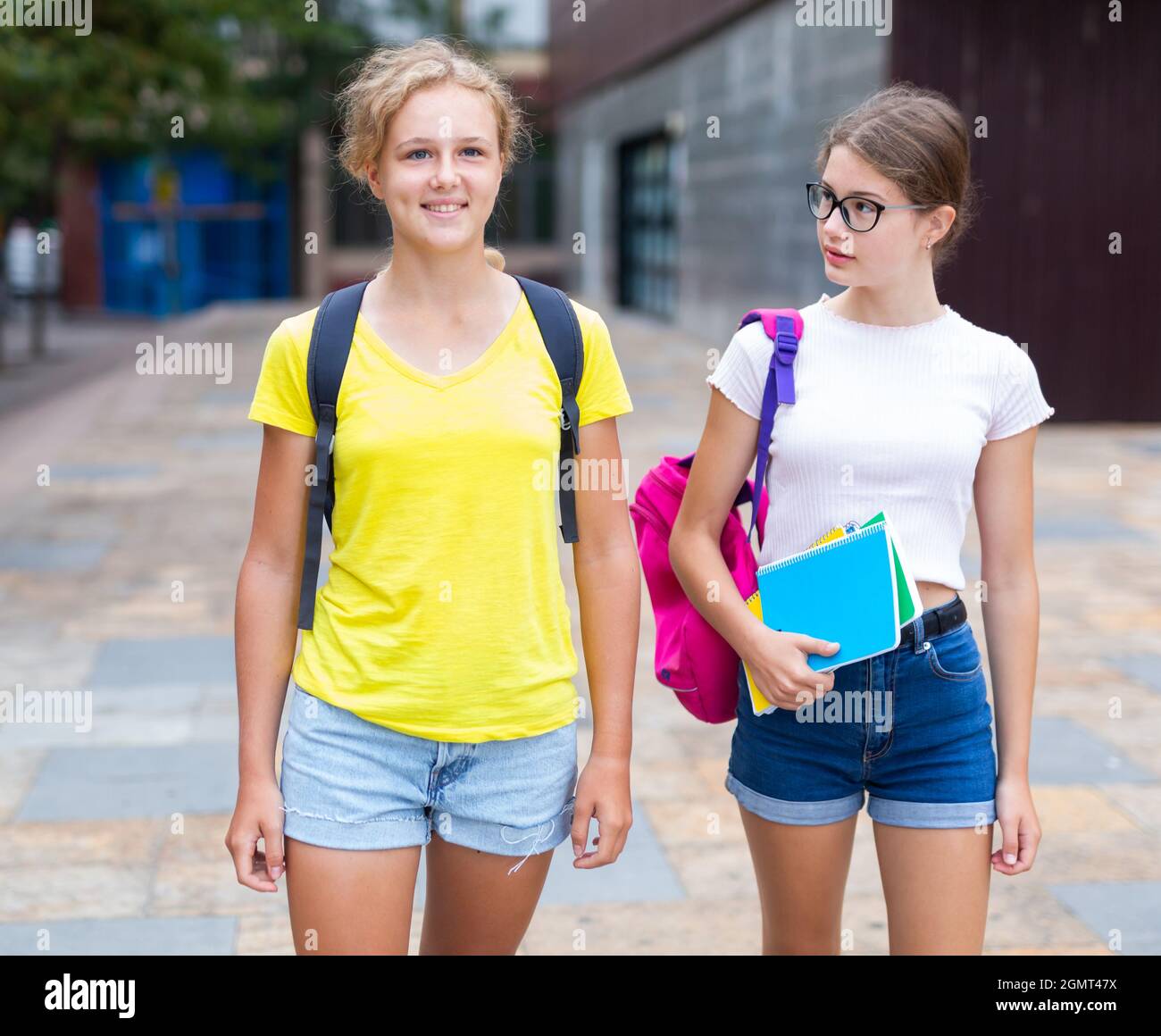 Two youth girls with backbacks going to school Stock Photo - Alamy