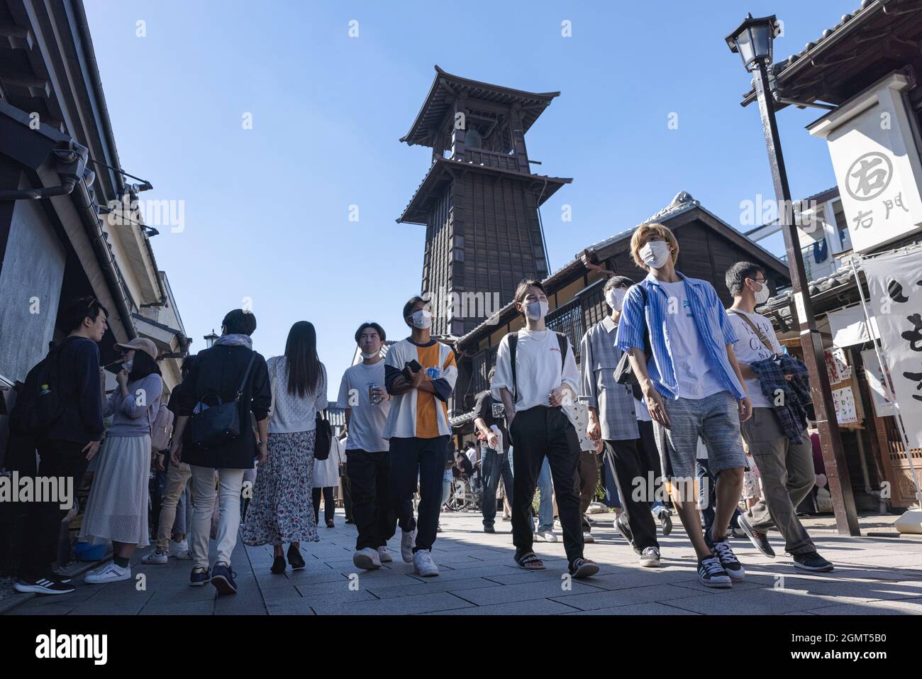 Kawagoe, Japan. 20th Sep, 2021. Pedestrians wearing face masks walk on ...