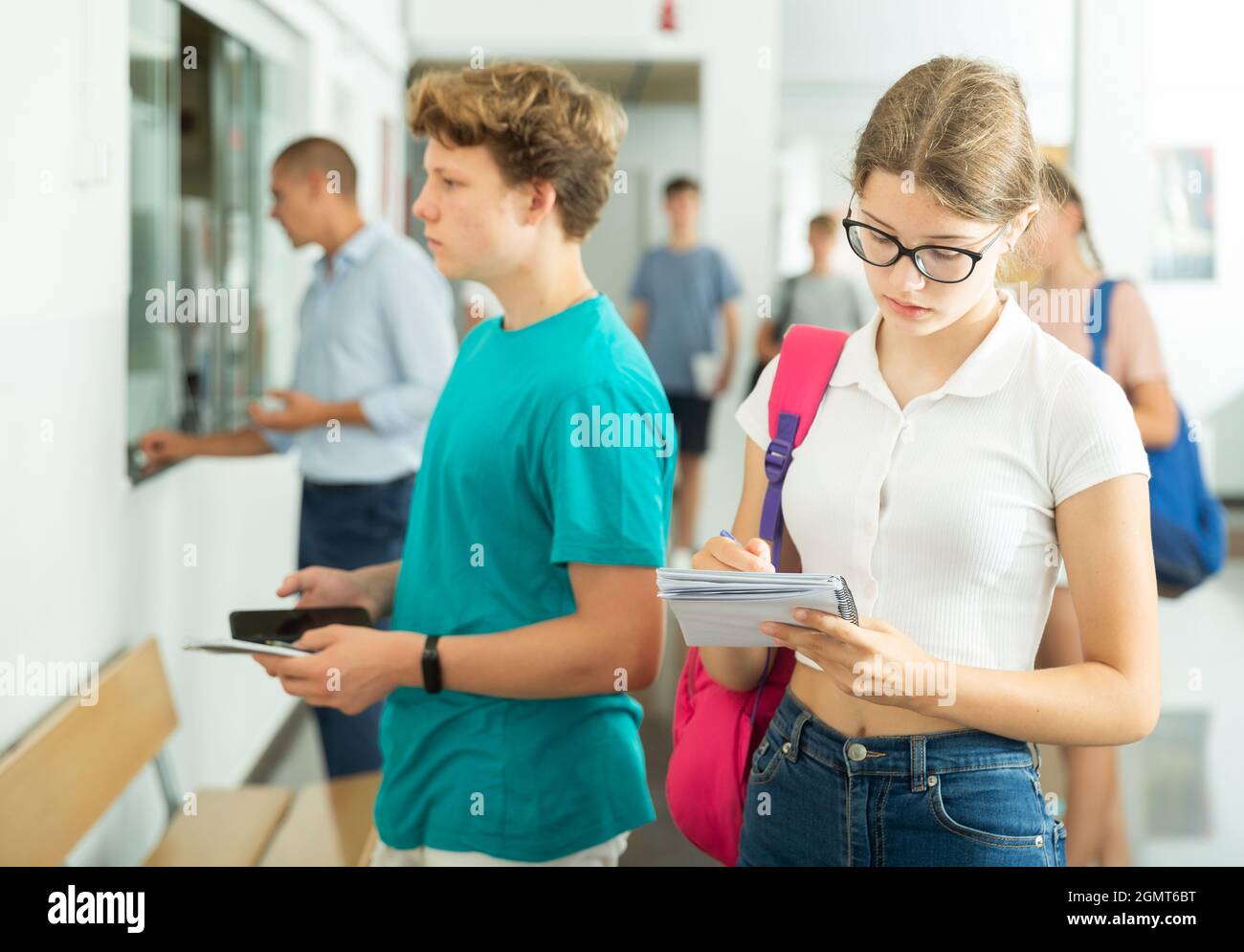 Students record and photograph class schedules in college lobby Stock ...