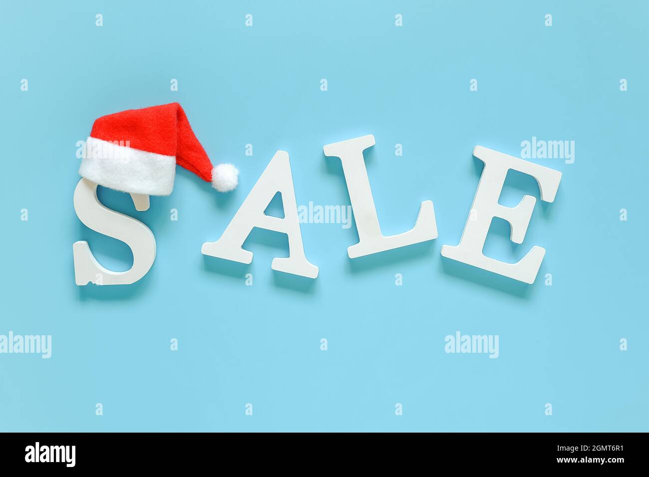 Text SALE from white letters and Santa Claus hat on blue background ...