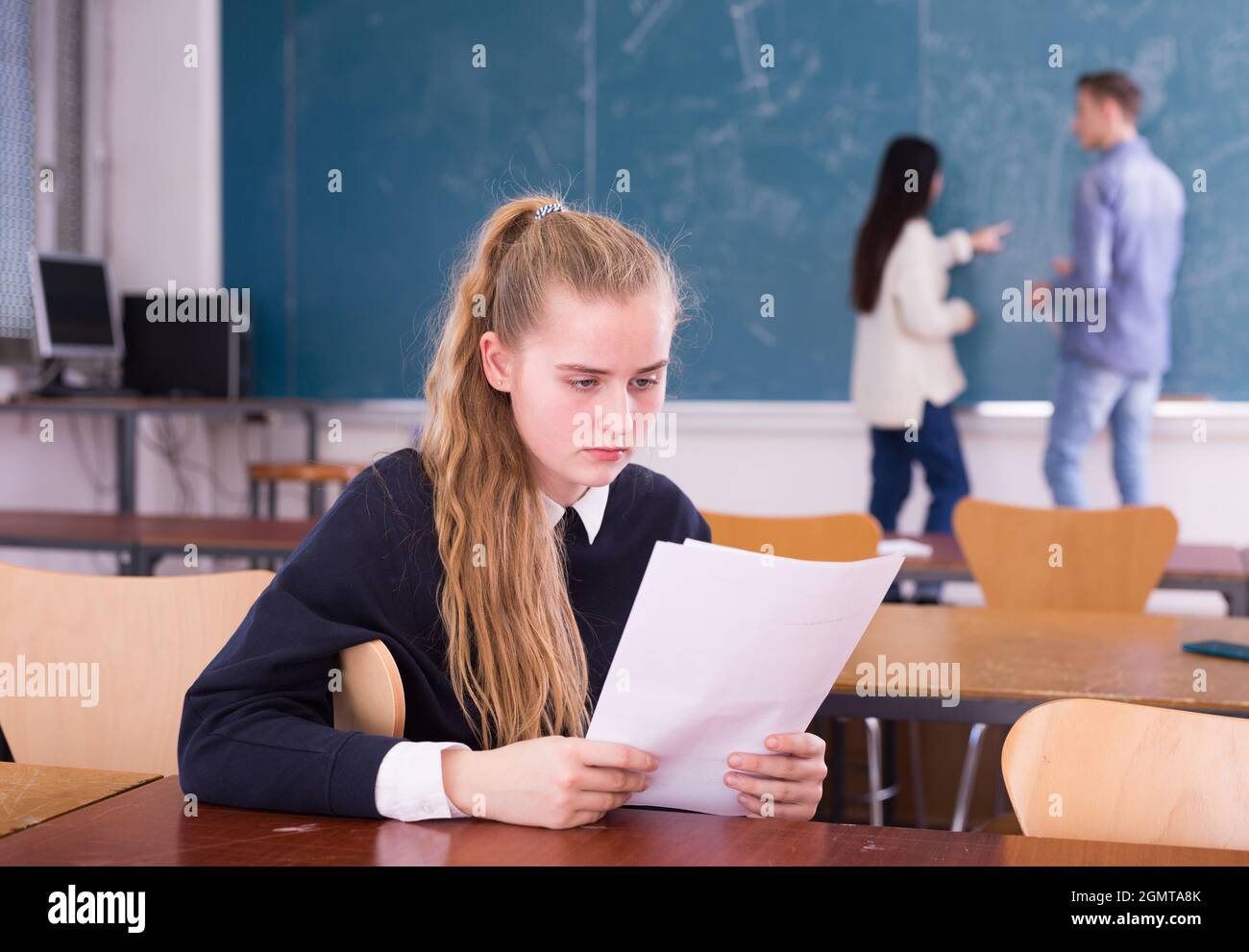 Frustrated girl student sitting in classroom with paper Stock Photo - Alamy