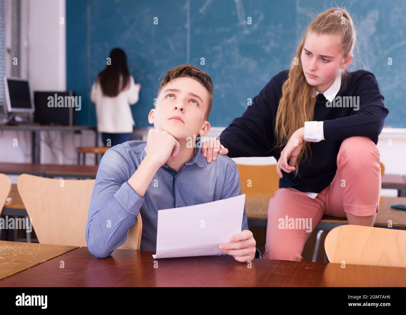 Girl student supporting upset friend in classroom Stock Photo - Alamy