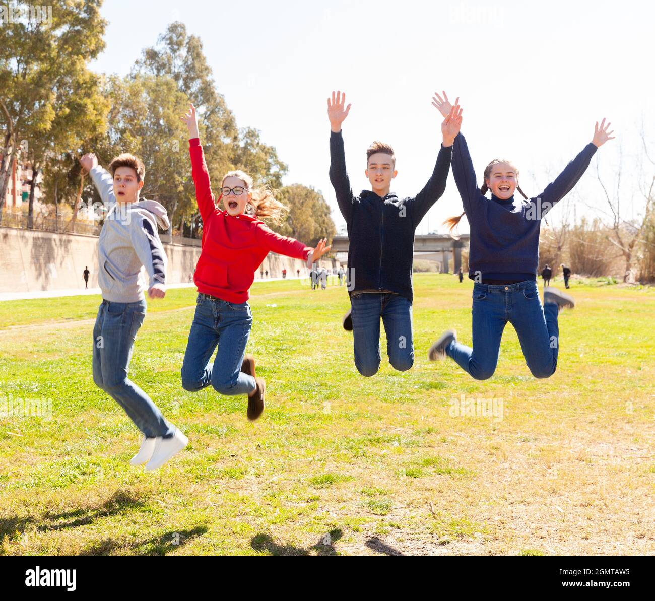 Teenagers jumping on green lawn Stock Photo - Alamy