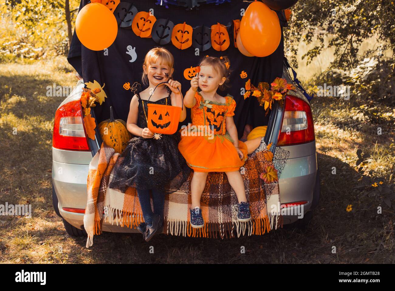 Children celebrating Halloween in trunk of car. Friends kids girls ...