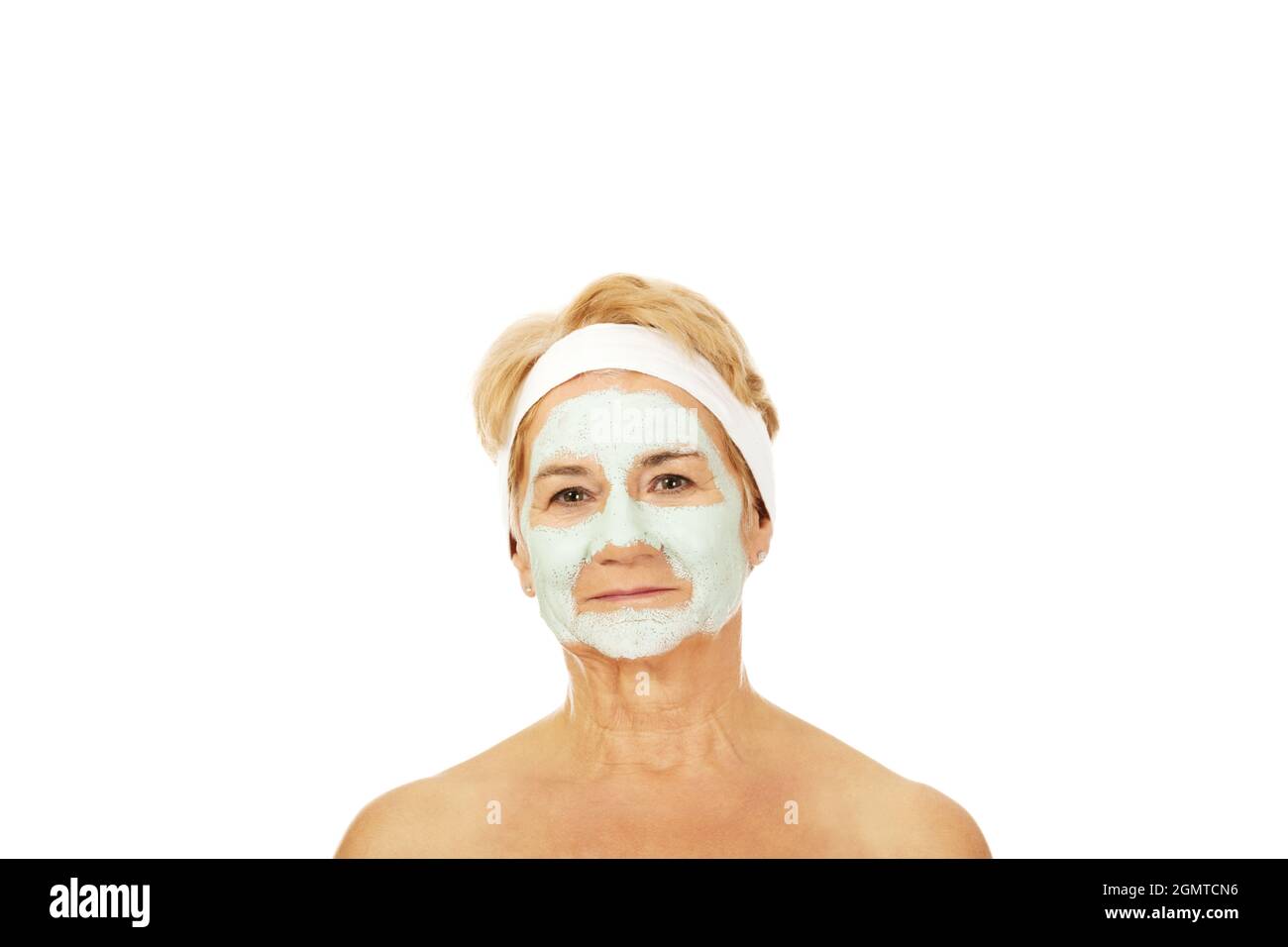 Senior Polish woman with face mask beauty treatment isolated on white ...