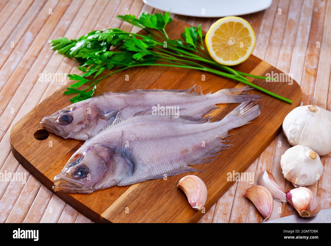Uncooked flatfish fish with parsley and garlic Stock Photo - Alamy