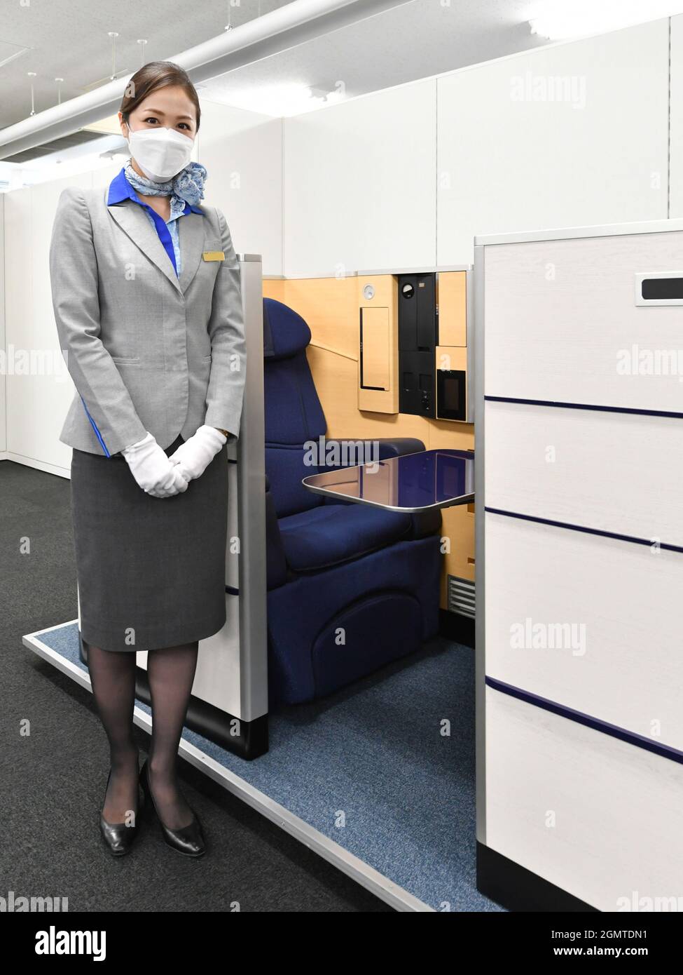 An ANA flight attendant introduces a mock-up of a Boeing 777-300ER ...