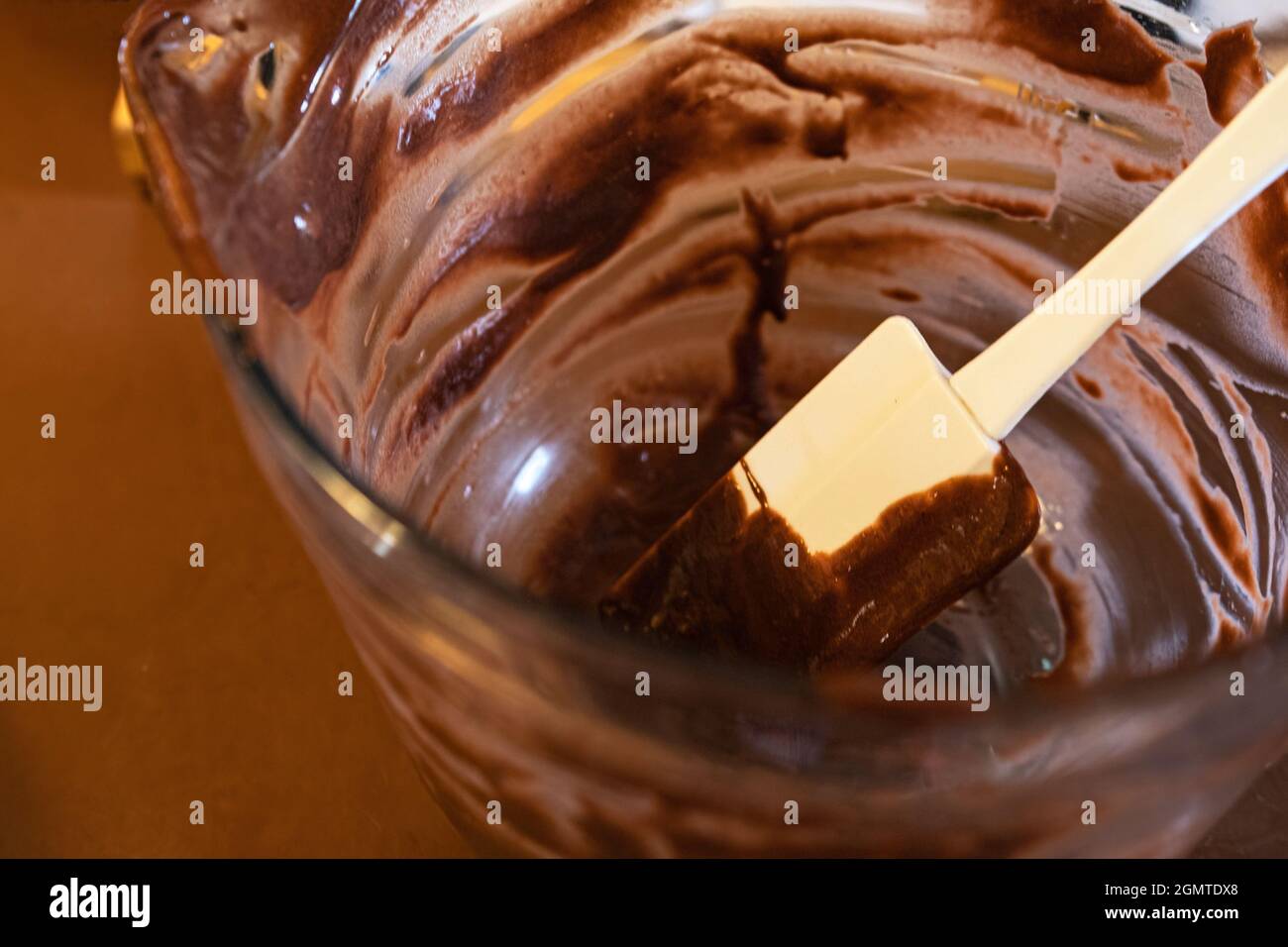 Empty glass mixing bowl with residue of chocolate cake batter on bowl ...