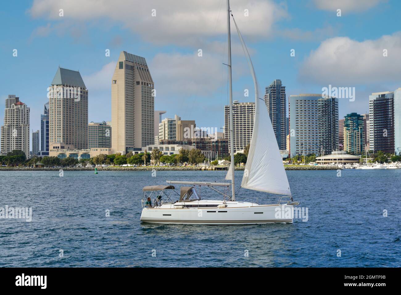 A sailboat leisurely sails in the San Diego Harbor by the Manchester ...