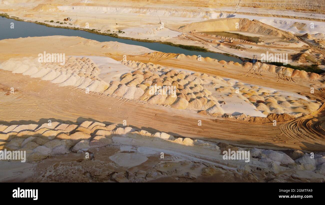Sand quarry. Turquoise lagoon and surface mine with exposed colored ...
