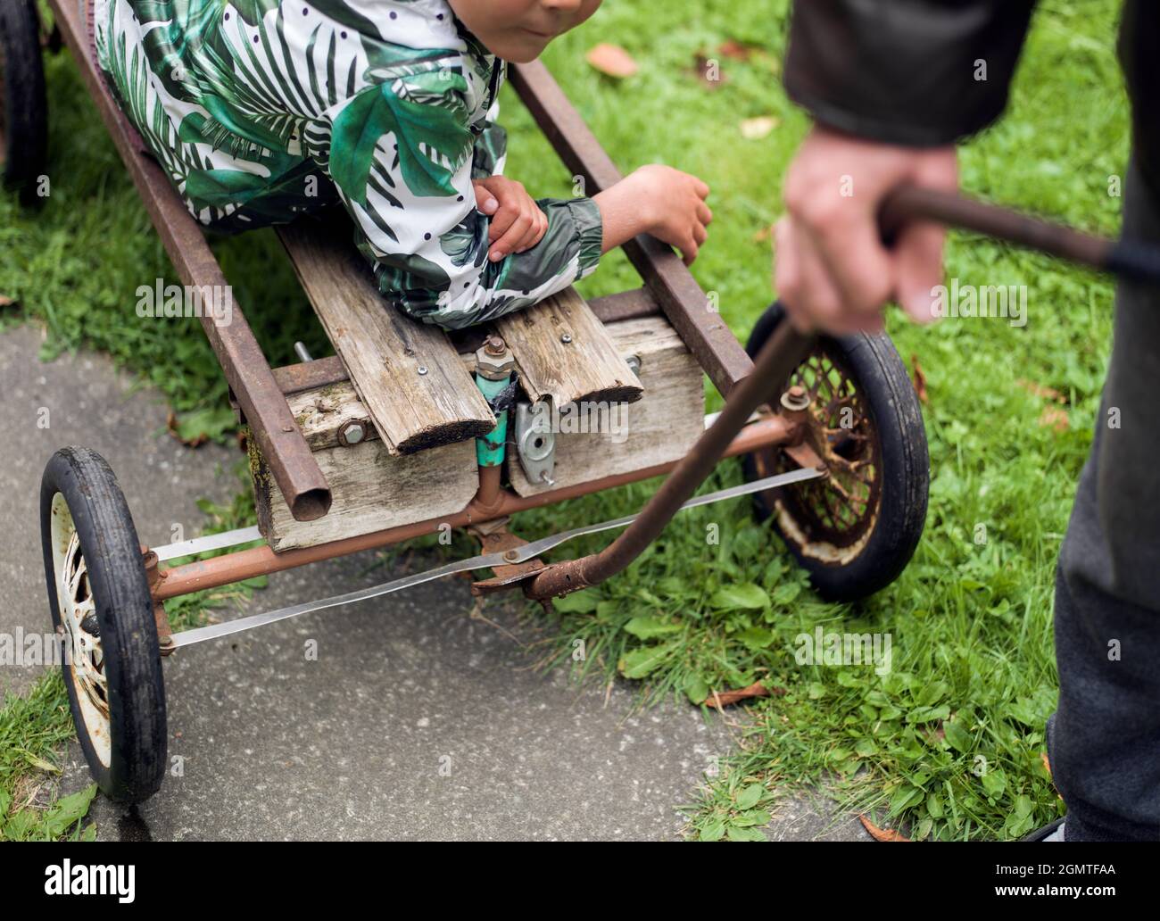 a hand pulling a handmade trolley with a child Stock Photo - Alamy