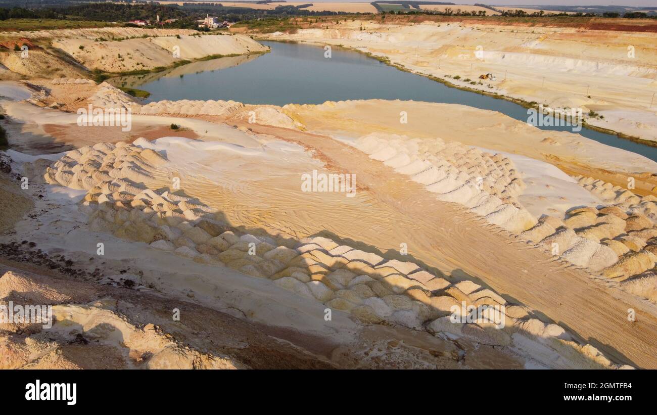 Sand quarry. Turquoise lagoon and surface mine with exposed colored ...