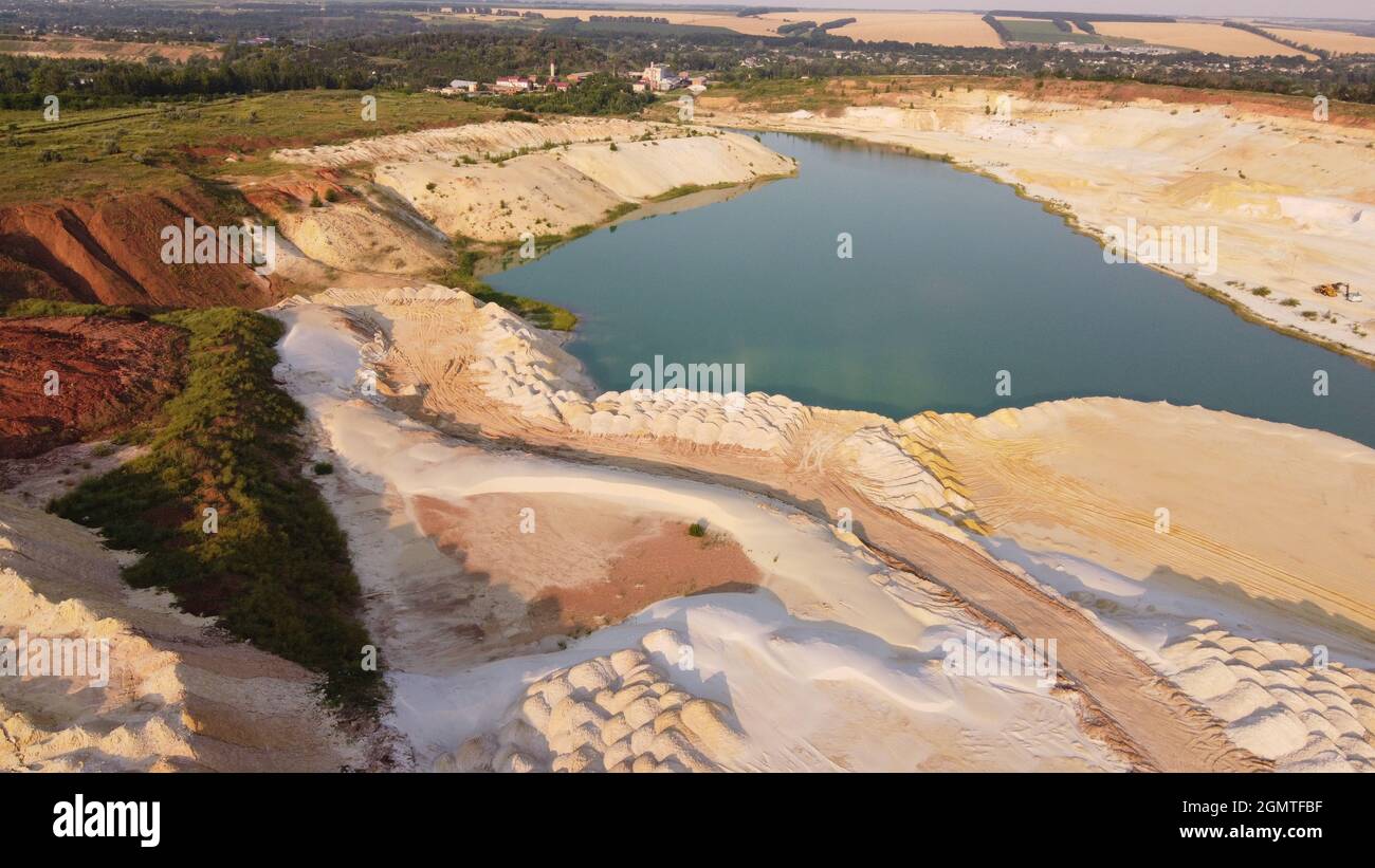 Sand quarry. Turquoise lagoon and surface mine with exposed colored ...