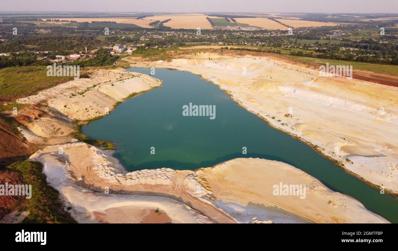 Sand quarry. Turquoise lagoon and surface mine with exposed colored ...