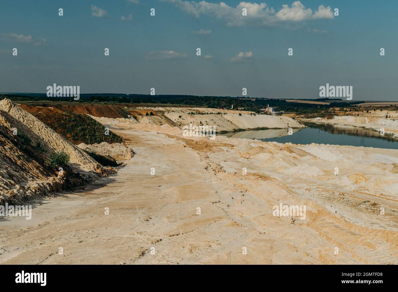 Sand quarry. Turquoise lagoon and surface mine with exposed colored ...