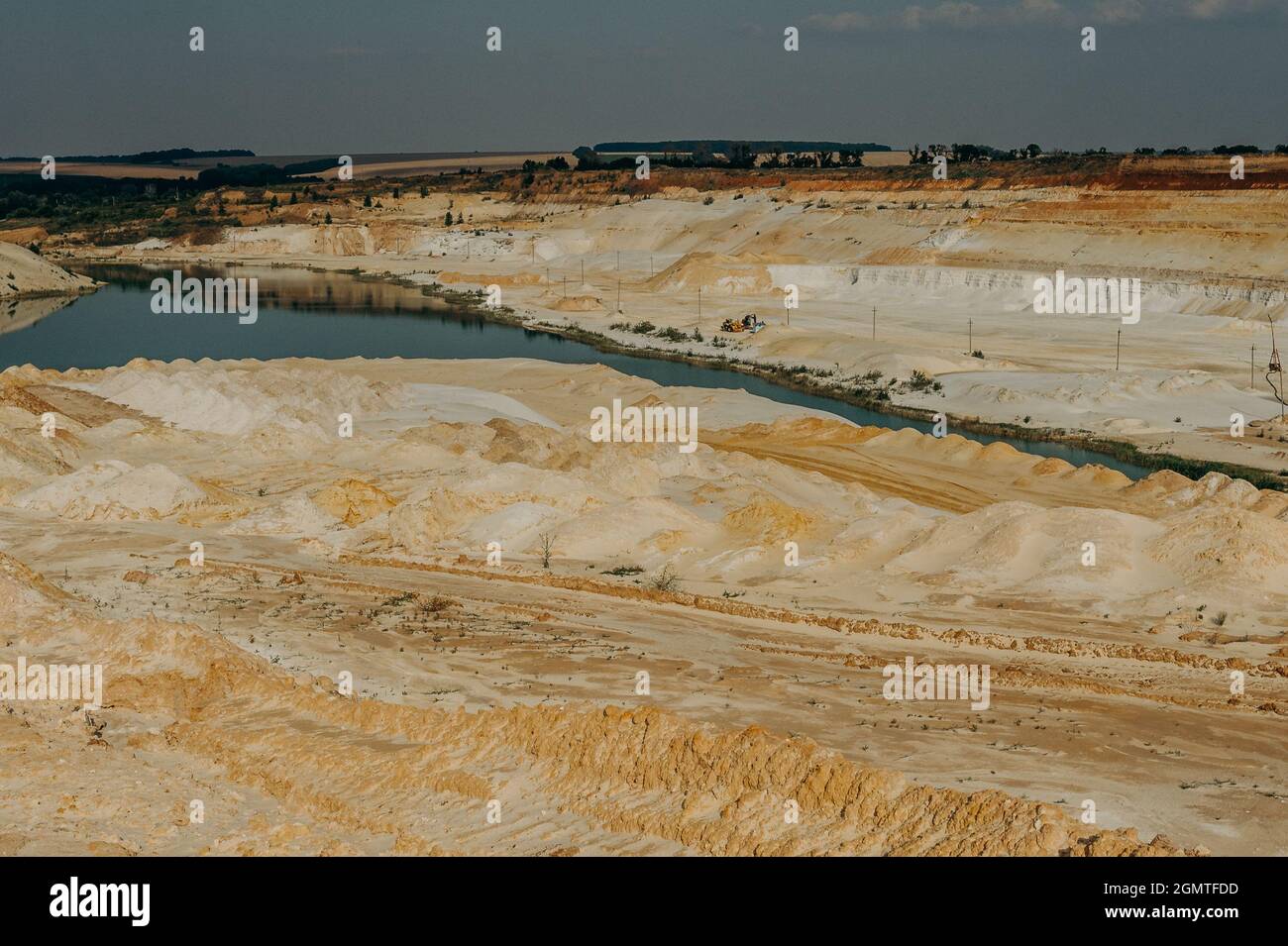 Sand quarry. Turquoise lagoon and surface mine with exposed colored ...