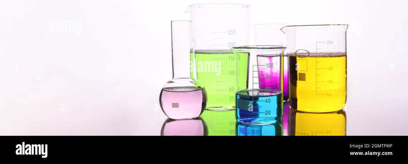 Glass flasks with multi-colored liquid on table Stock Photo - Alamy