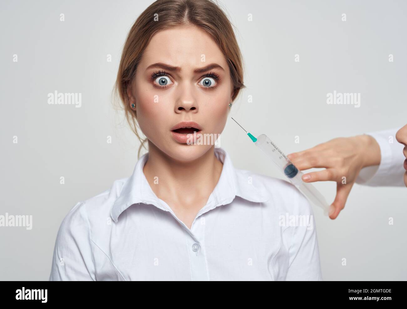 woman patient syringe in the hands of a doctor fear of injections ...