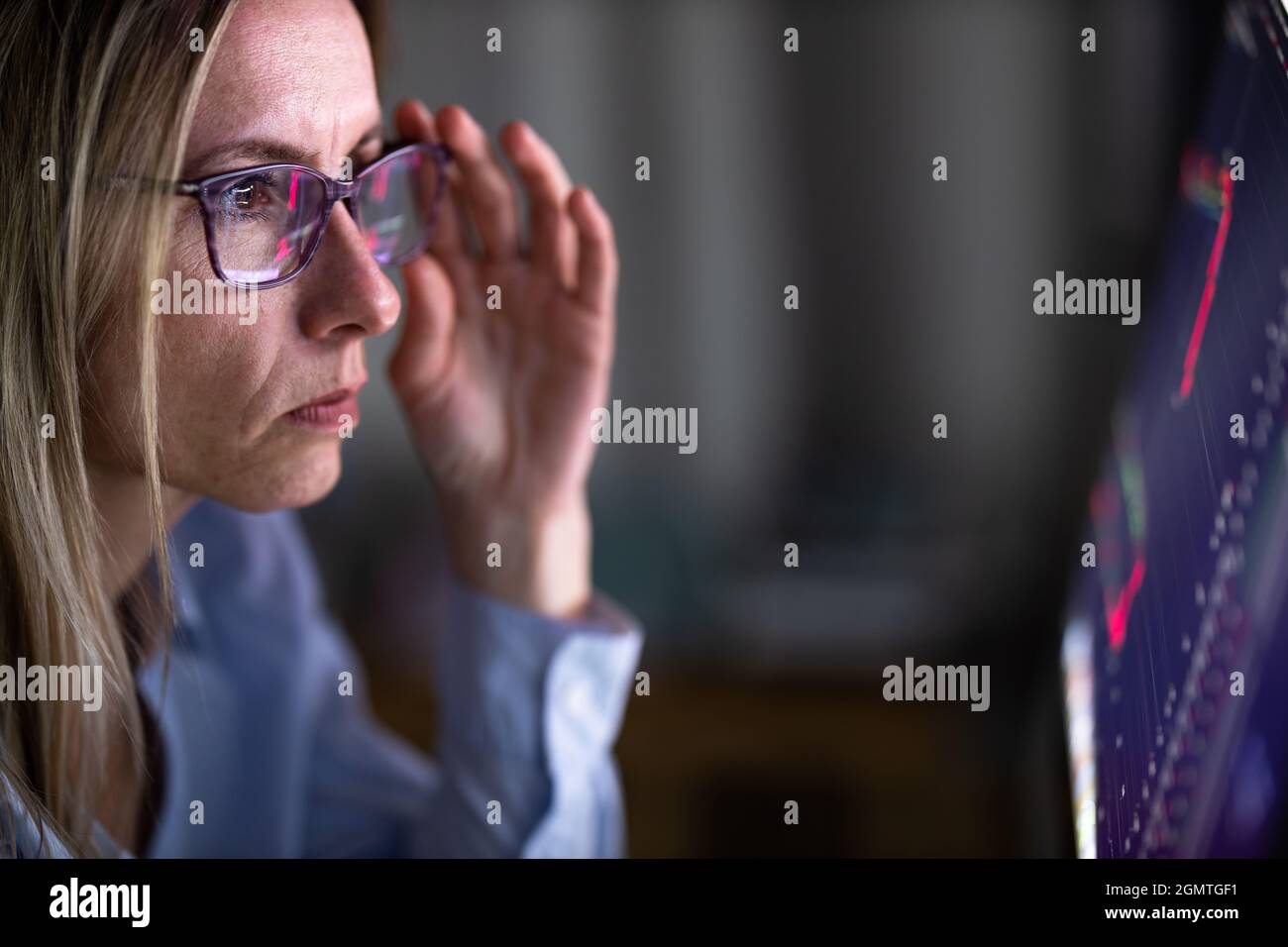Stylish mid-aged woman looking concerned while remote working from home ...