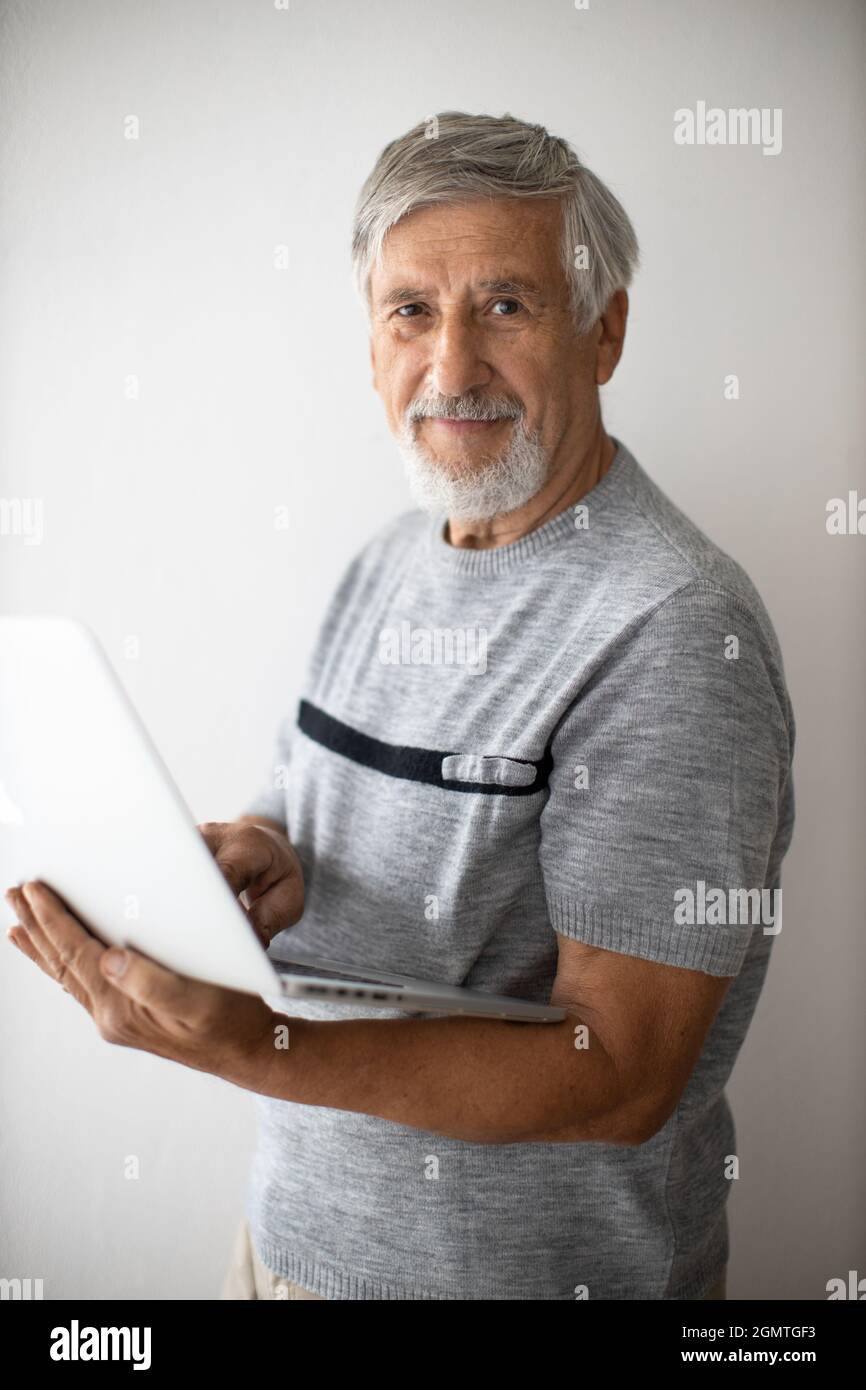 Senior man with a modern laptop computer, using the computer without ...