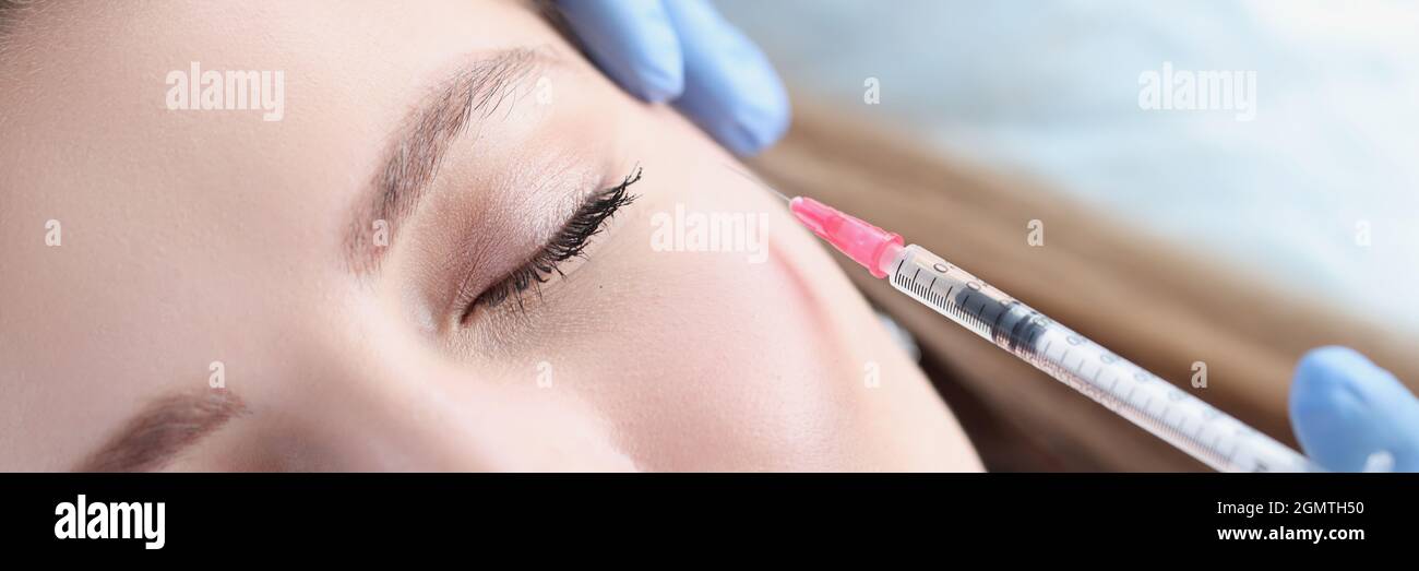 Woman is injected with rejuvenating injection with hyaluronic acid in ...