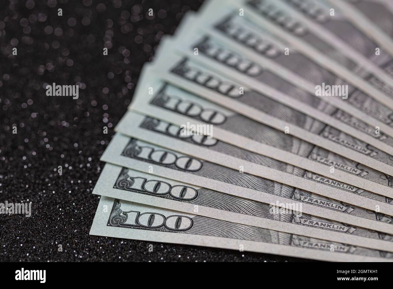 fan of 100 dollar banknotes on black glitter background Stock Photo - Alamy