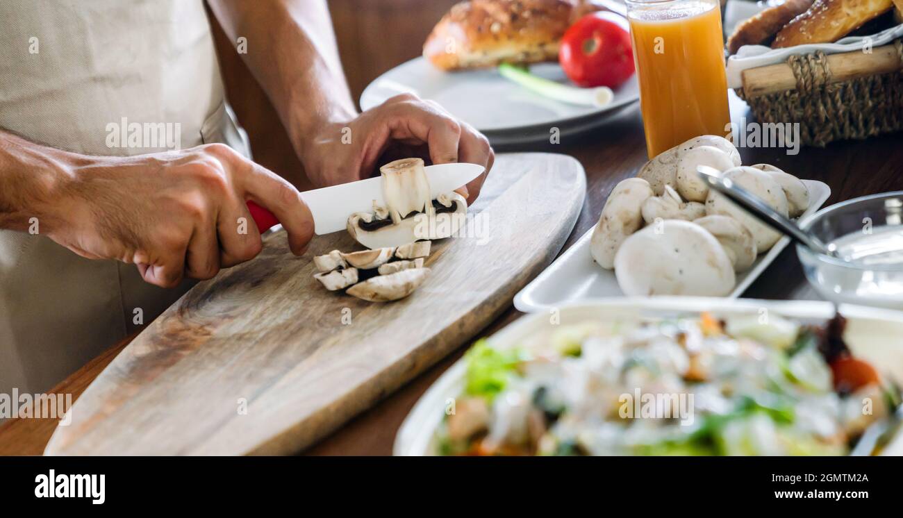 Cooking, food and people concept. Close up of male hand cutting ...