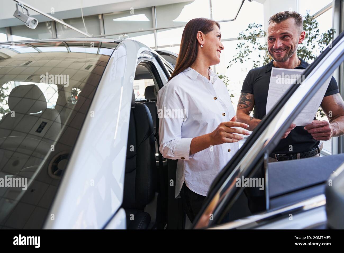 Friendly conversation in car dealership before the purchase Stock Photo ...