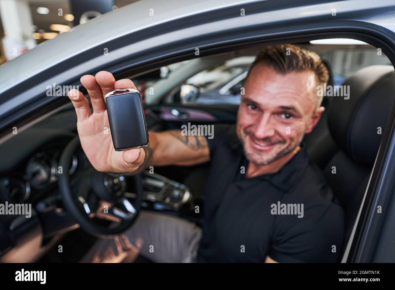 Happy owner of the modern car looking pleased Stock Photo - Alamy
