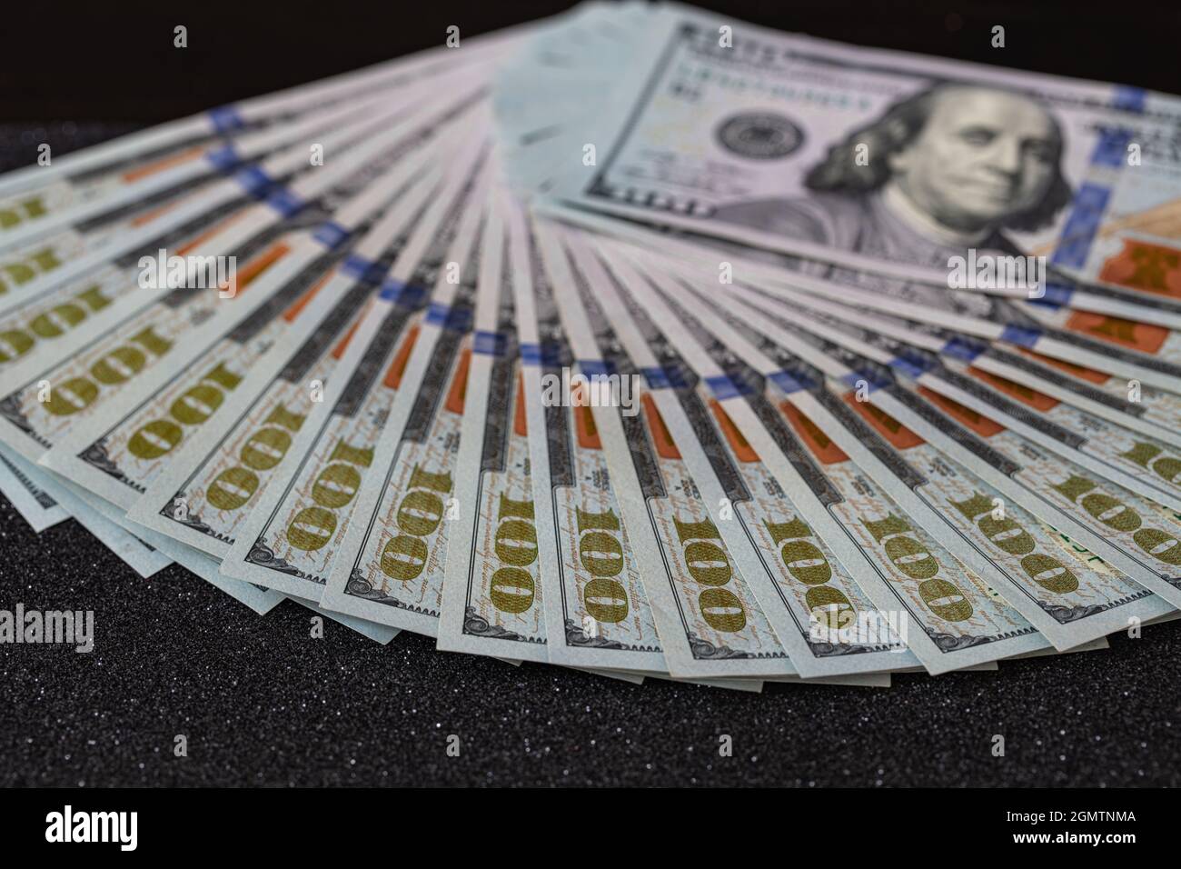 fan of 100 dollar banknotes on black glitter background Stock Photo - Alamy