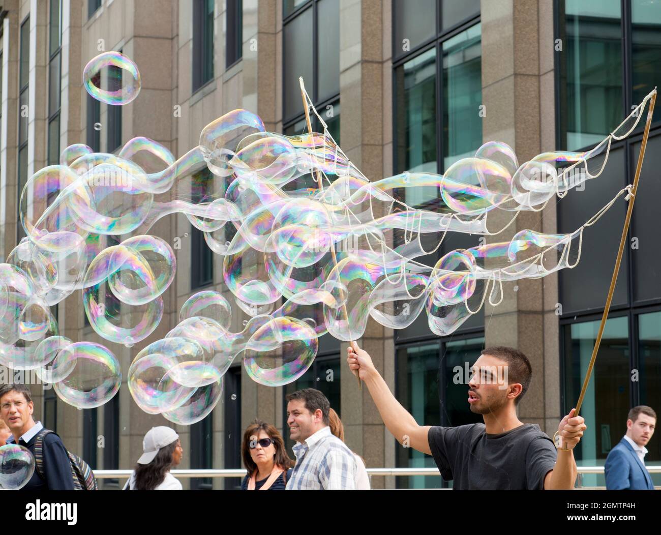 London, UK - 18 August 2016; man blowing bubble and passers by. Princes ...