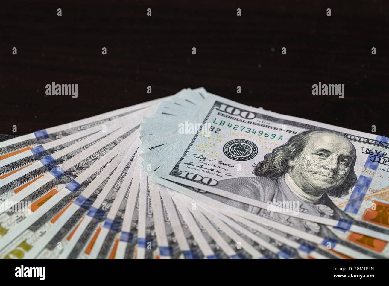 fan of 100 dollar banknotes on black glitter background Stock Photo - Alamy