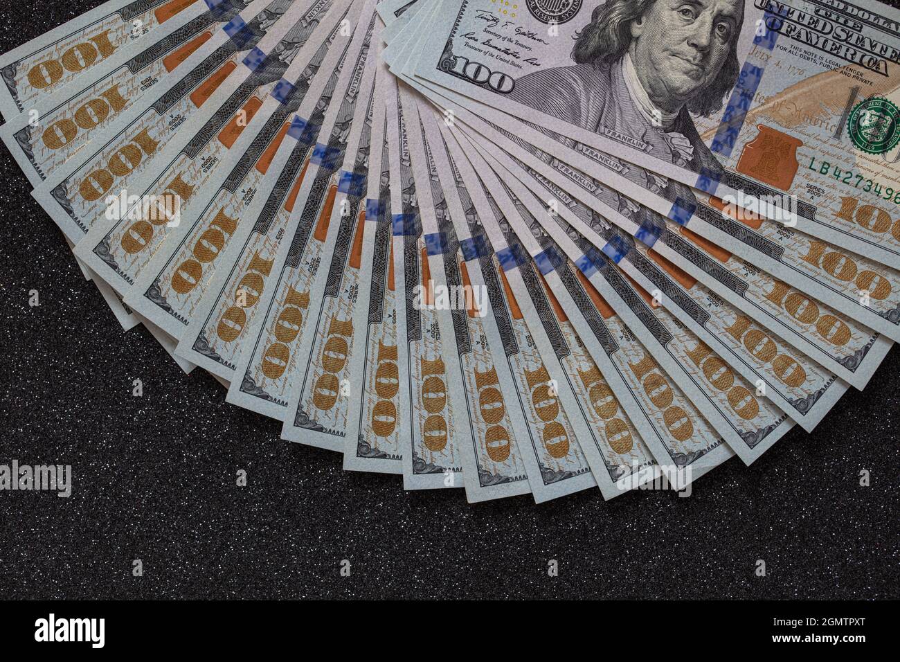 fan of 100 dollar banknotes on black glitter background Stock Photo - Alamy