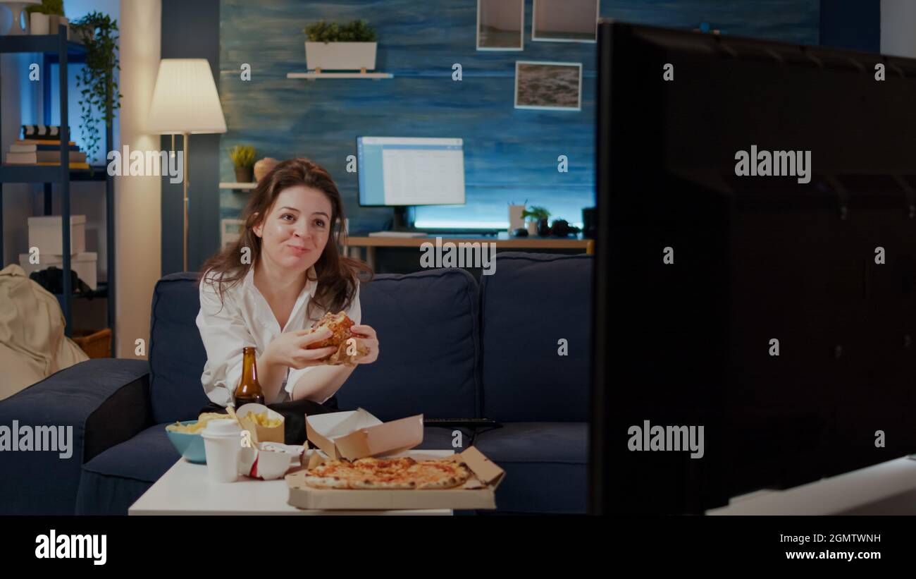 Person eating delicious hamburger and fries in living room while ...