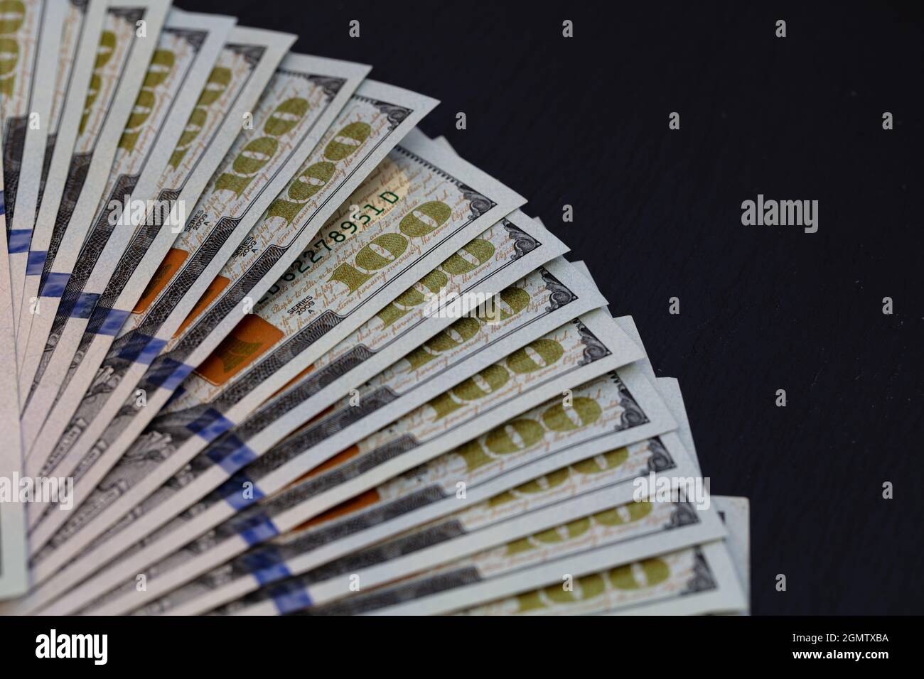 fan of 100 dollar banknotes on black glitter background Stock Photo - Alamy