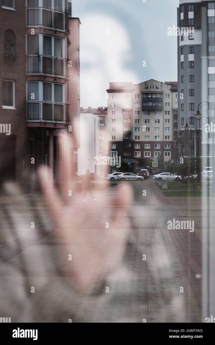 sad lonely young woman looking through window at modern city Stock ...