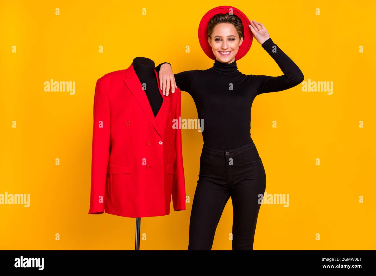Portrait of attractive cheerful girl posing with dummy creating suit ...