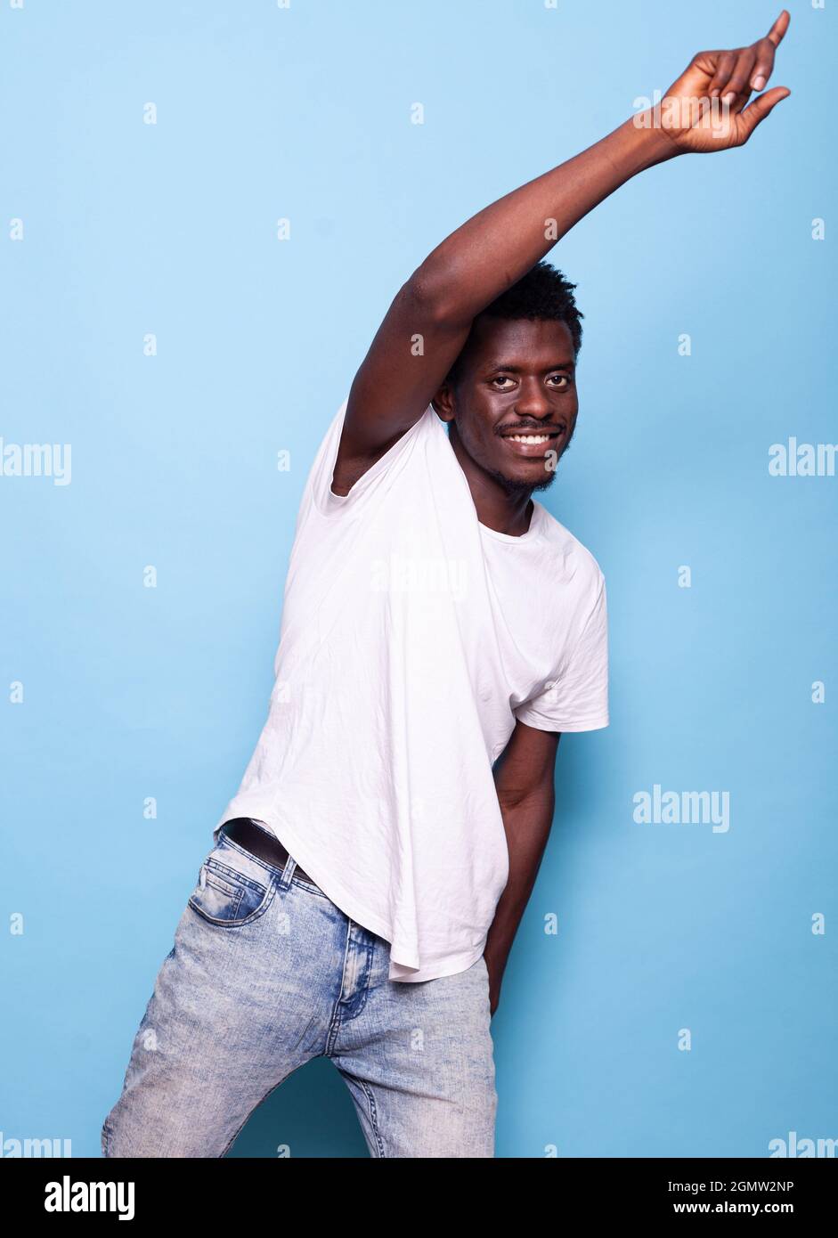 Carefree adult dancing and smiling while looking at camera. Portrait of ...
