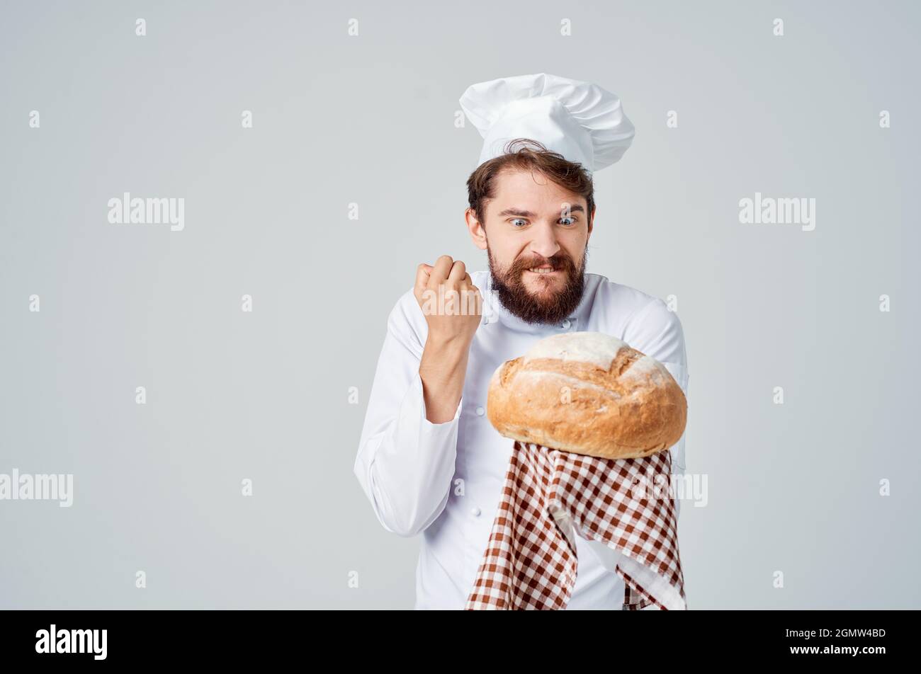 bearded man chef with bread in hand light background Stock Photo - Alamy