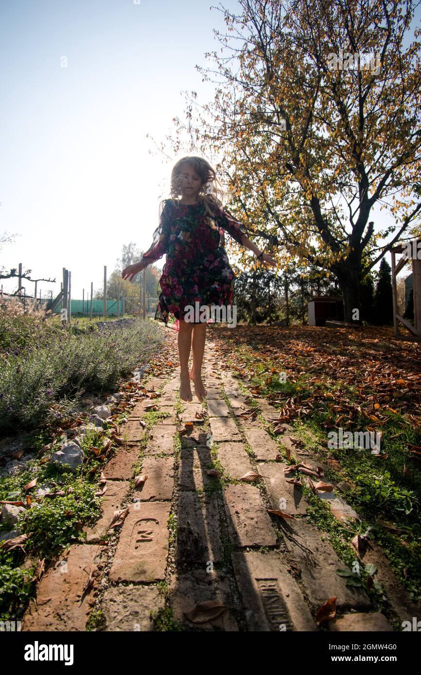 child in beautiful dress dancing wild in sunny afternoon Stock Photo ...