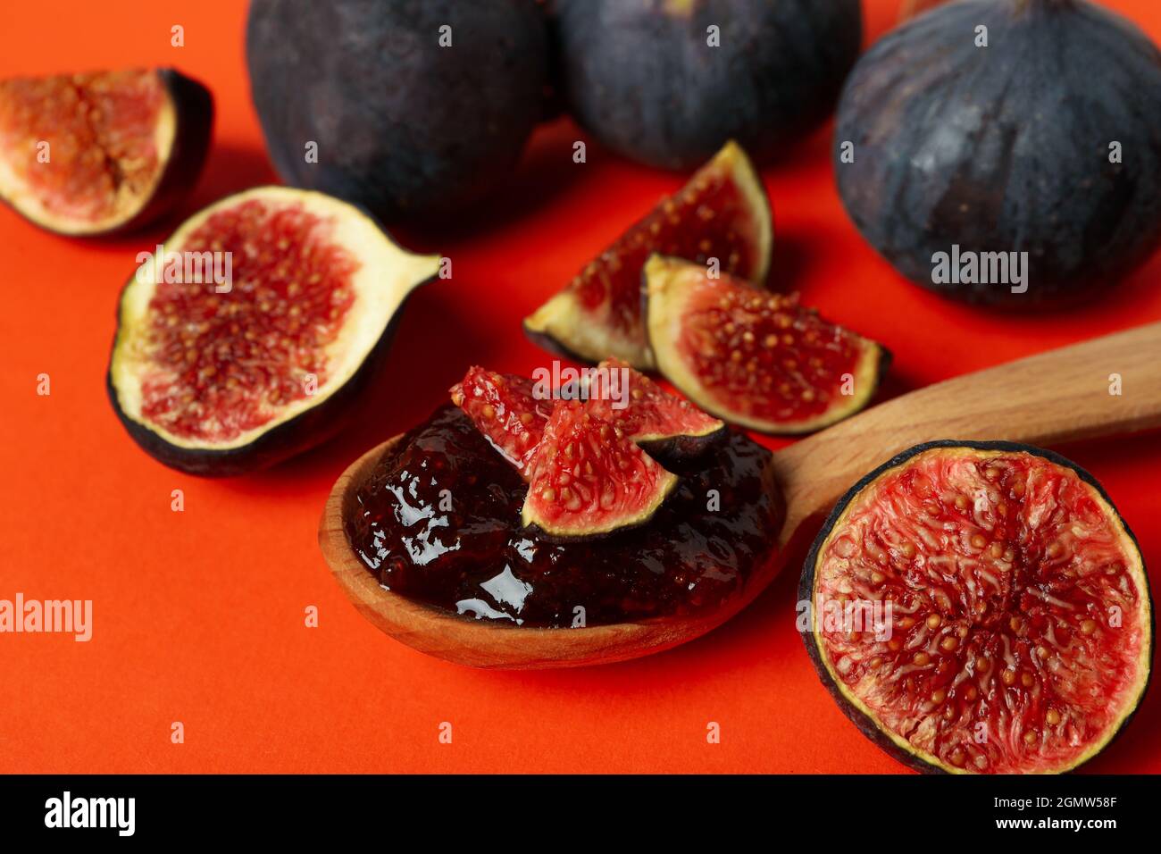 Spoon with fig jam and ingredients on orange background Stock Photo - Alamy