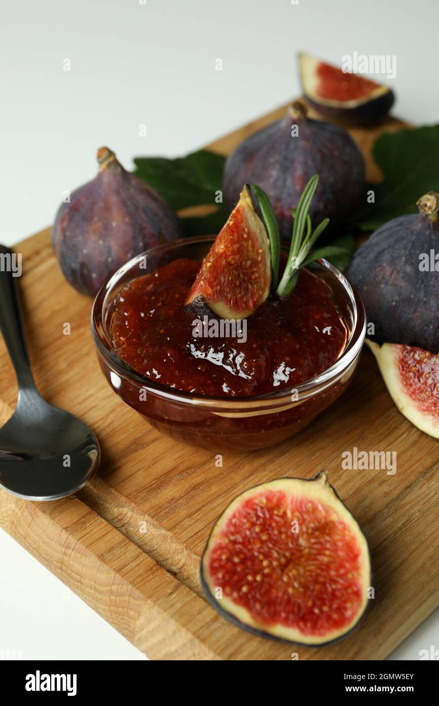 Board with fig jam, ingredients and spoon on white background Stock ...