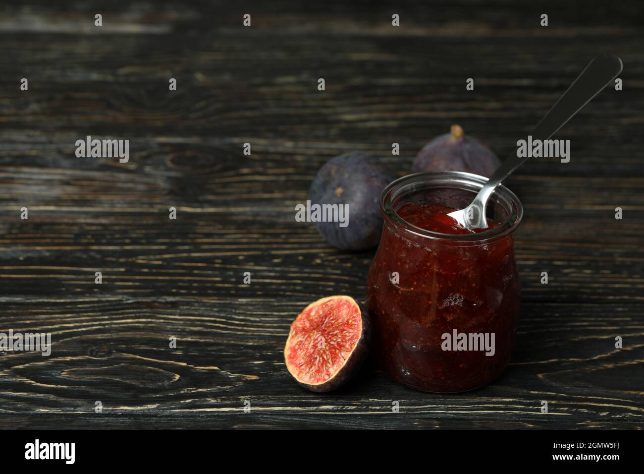 Jar with fig jam and spoon, and ingredients on wooden background Stock ...